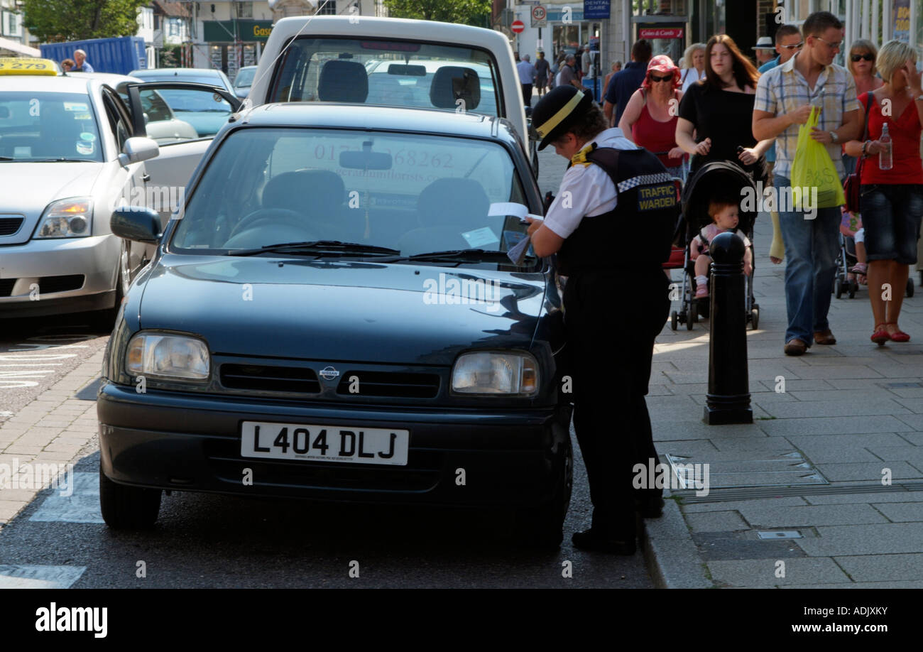 Traffic warden writing out a parking ticket Law enforcement officer ...
