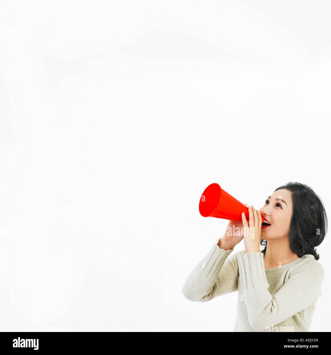 A smiling woman shouting with a funnel Stock Photo - Alamy