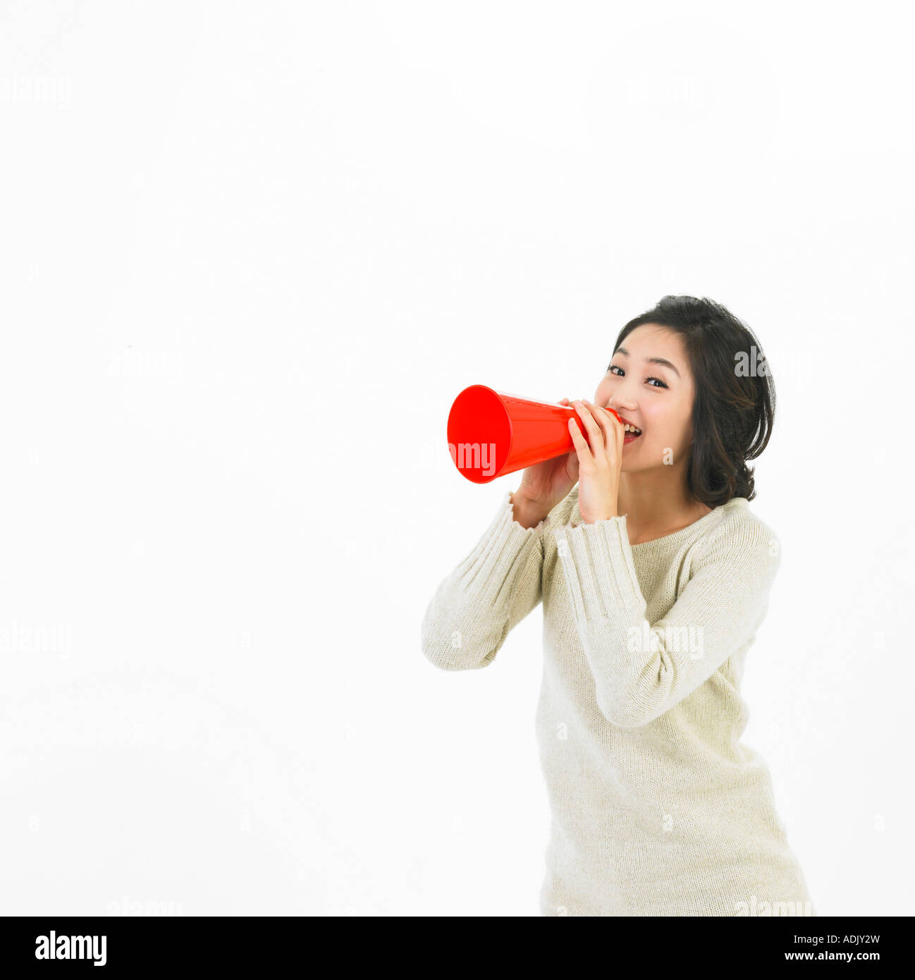 A smiling woman shouting with a funnel Stock Photo - Alamy