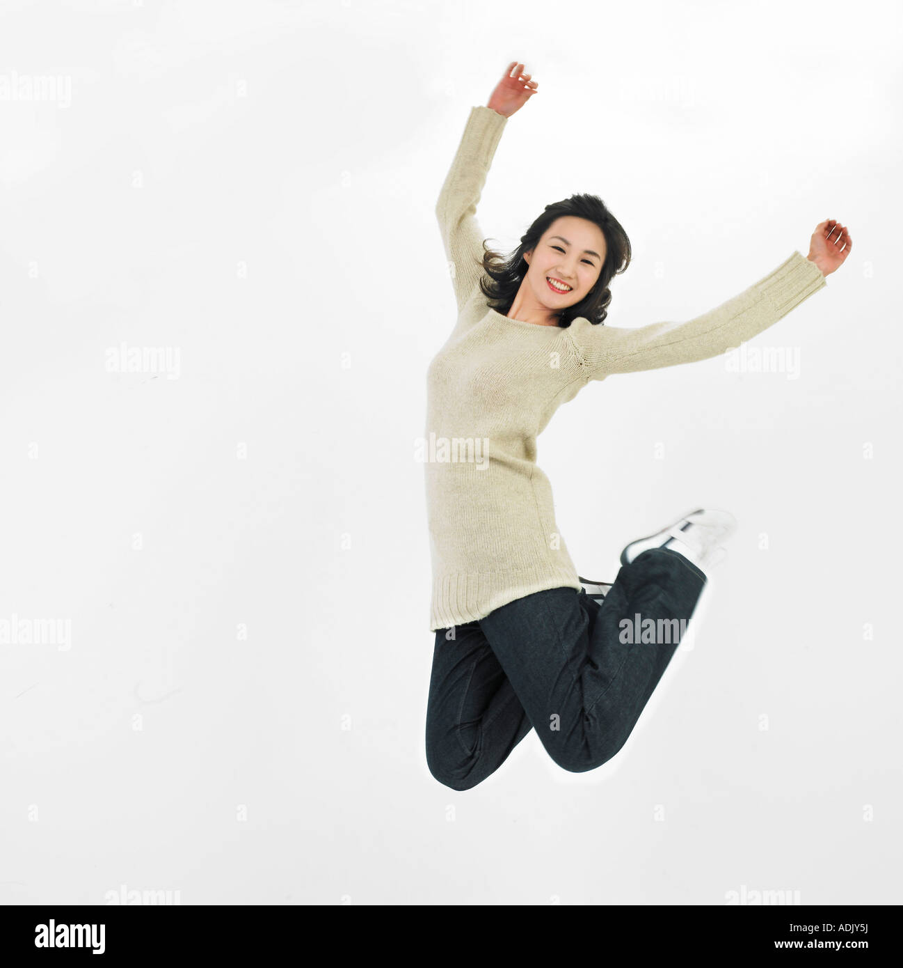 A smiling woman jumping up happily Stock Photo - Alamy