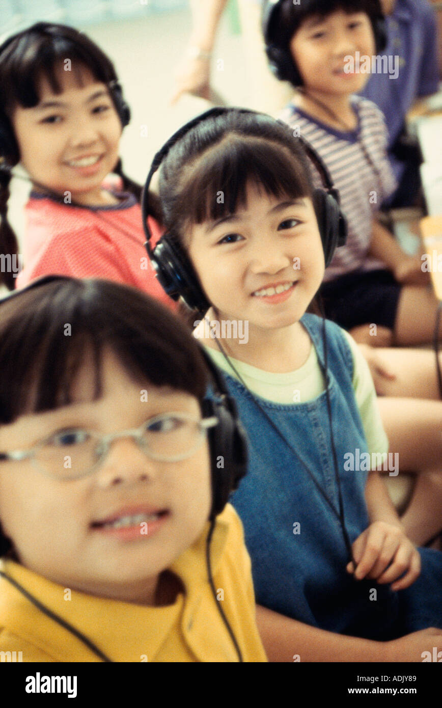 Portrait of a group of children wearing headphones smiling Stock Photo ...