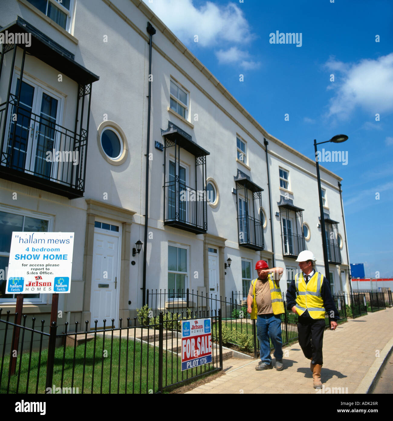 Architect and builder wearing dayglow vests and hard hats checking ...