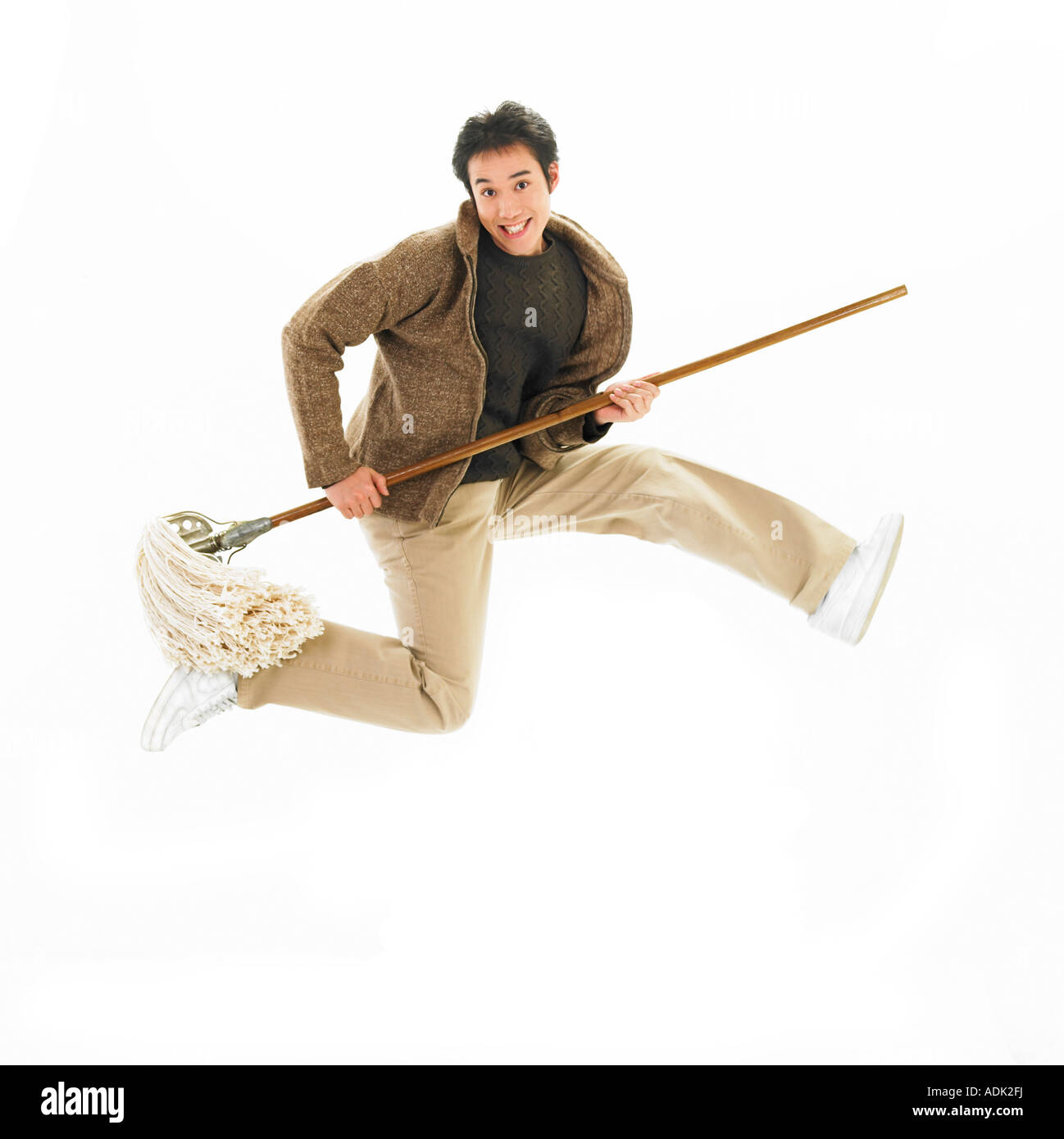 A young man jumping up with a broomstick Stock Photo - Alamy