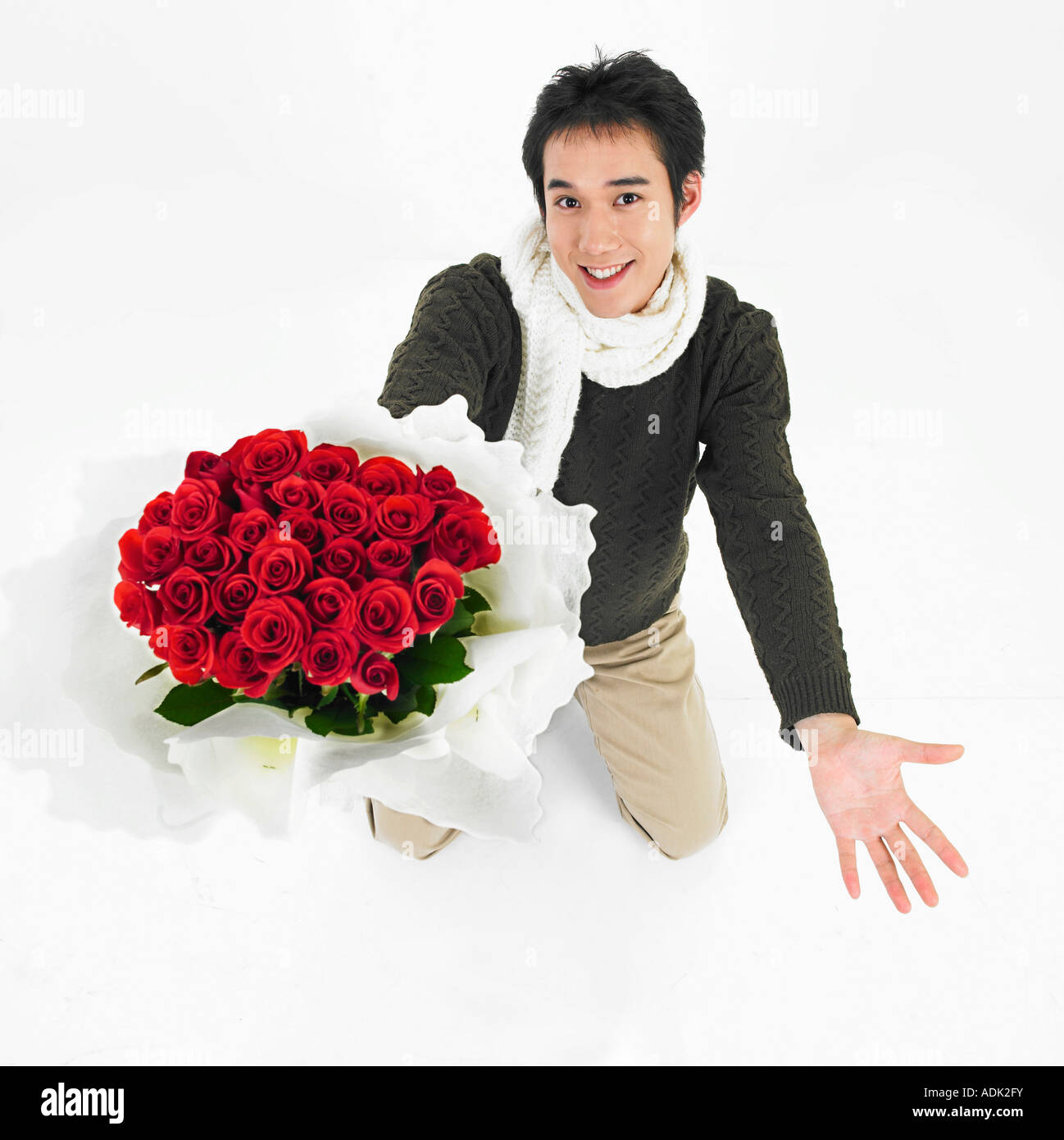 A young man holing a bunch of flowers with a smile Stock Photo - Alamy