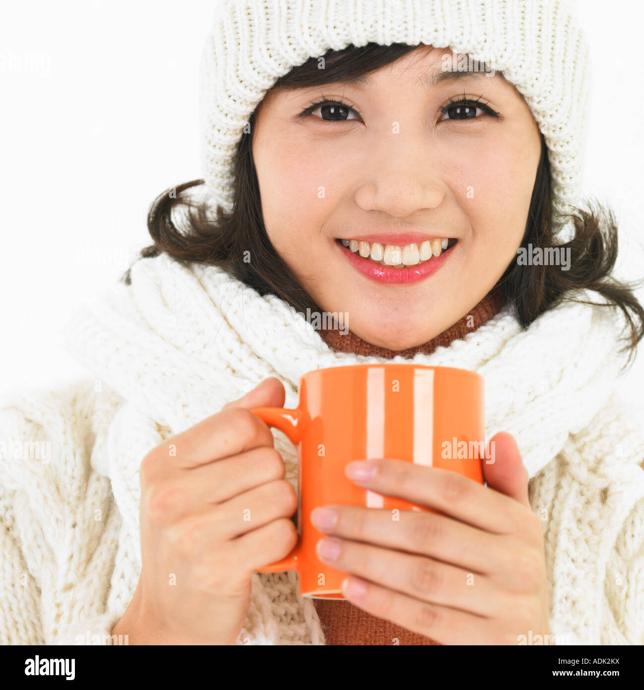 A young woman drinking a cup of tea with a smile Stock Photo - Alamy