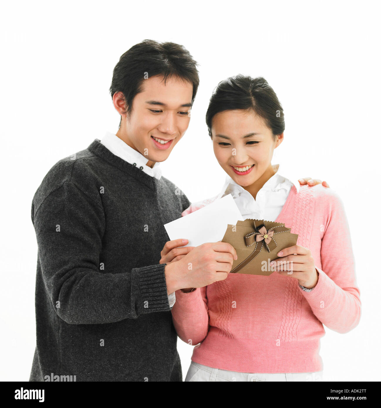 A young woman and a man reading a letter with a smile Stock Photo - Alamy
