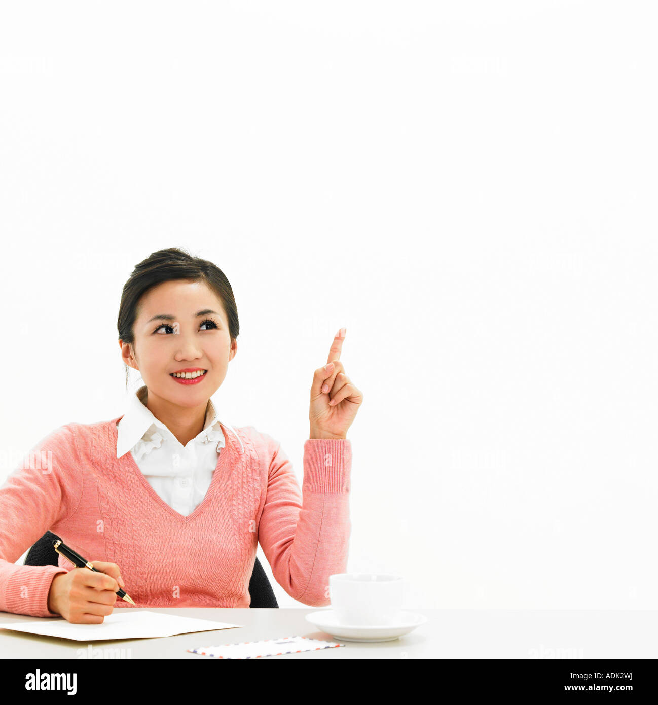 A young woman writing a letter with a smile Stock Photo - Alamy