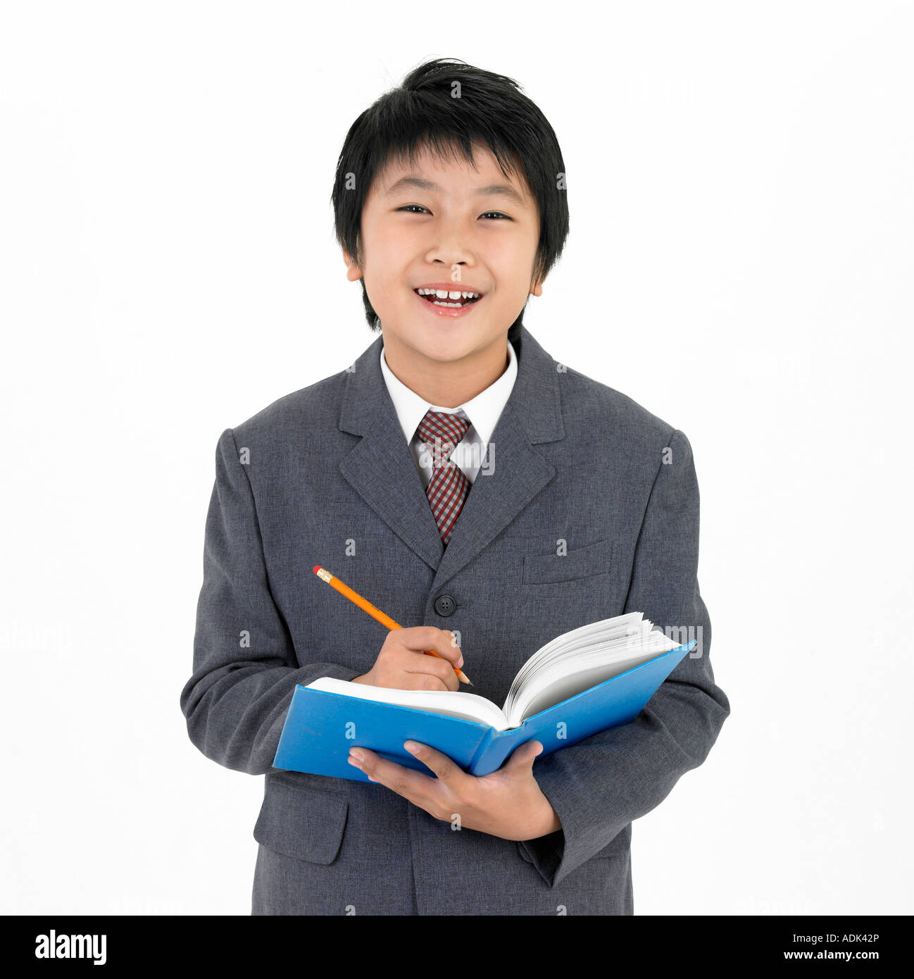 a boy holding a pencil and a notebook with a smile Stock Photo - Alamy