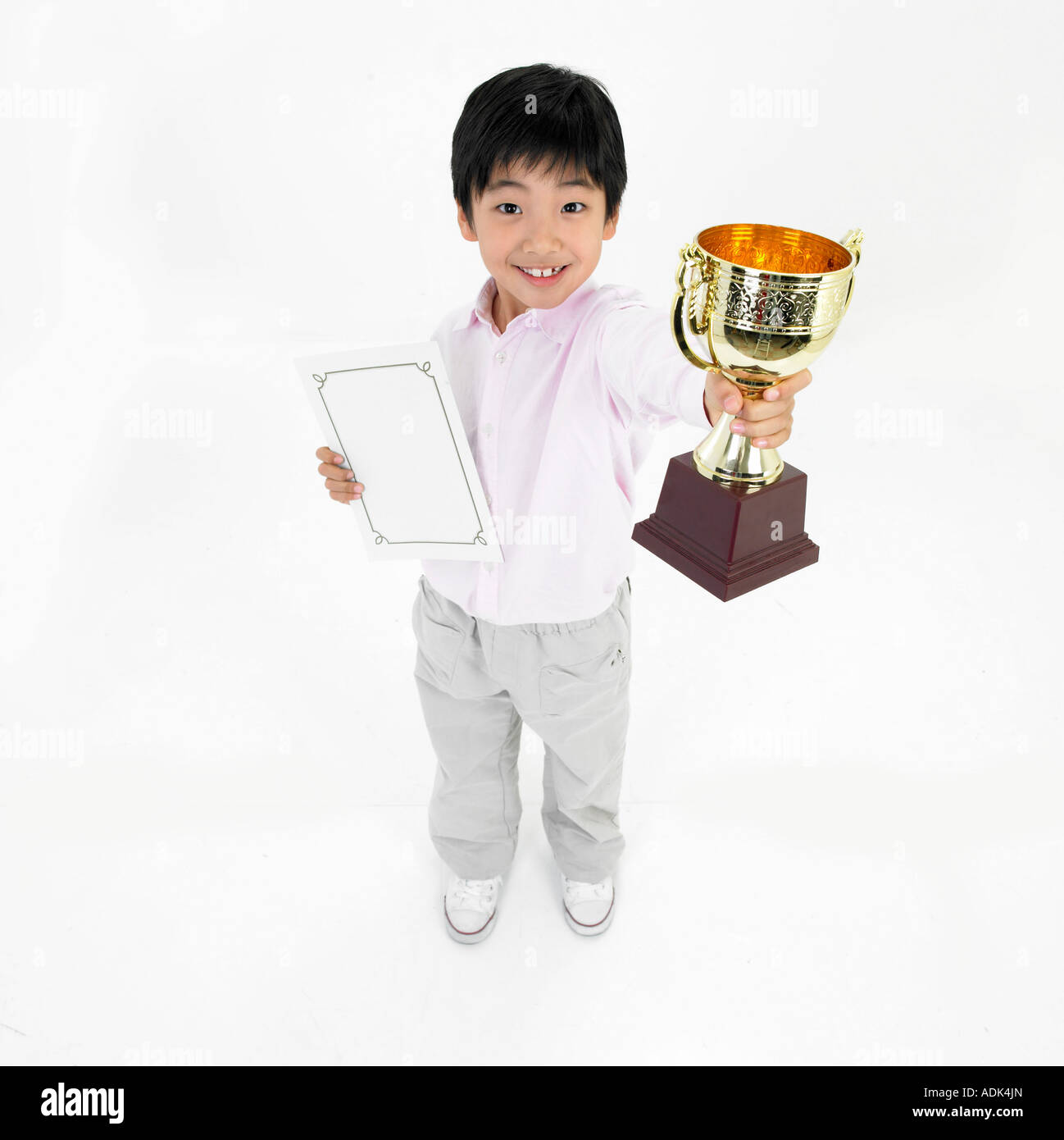 a boy holding a trophy and a testimonial with a smile Stock Photo - Alamy