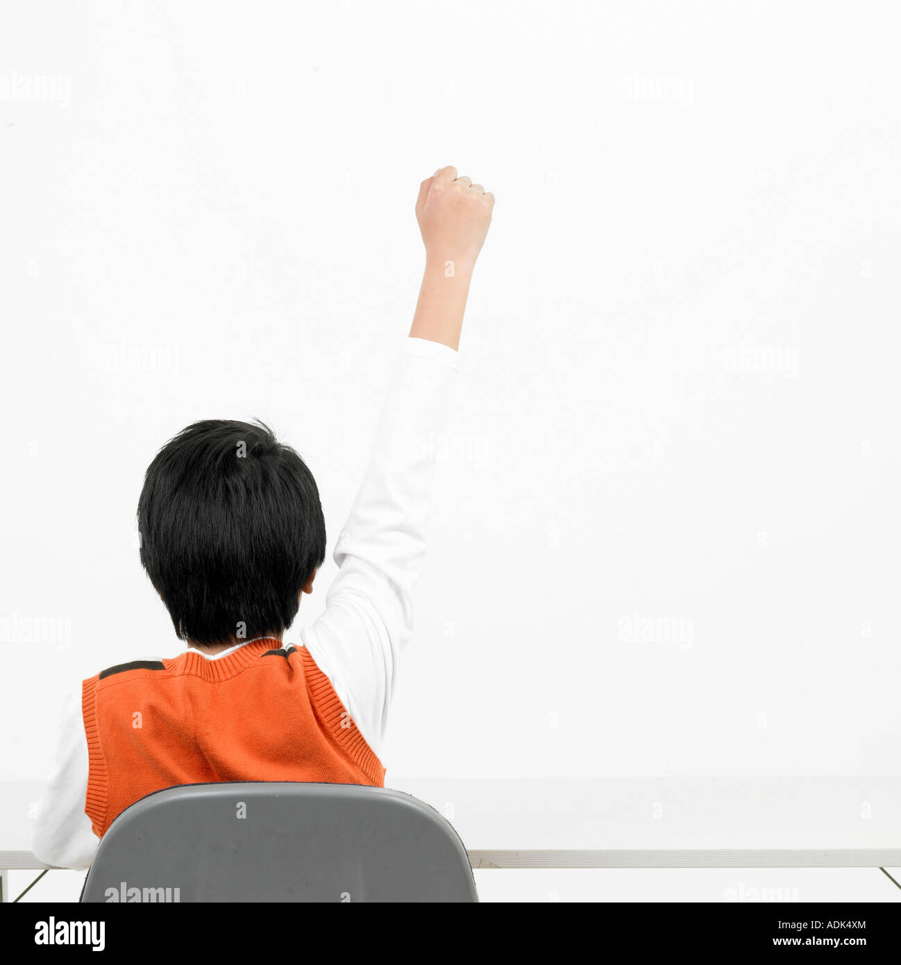 a boy raising his hand in the classroom Stock Photo - Alamy