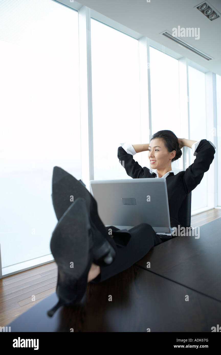 a businesswoman putting her feet on the desk Stock Photo - Alamy
