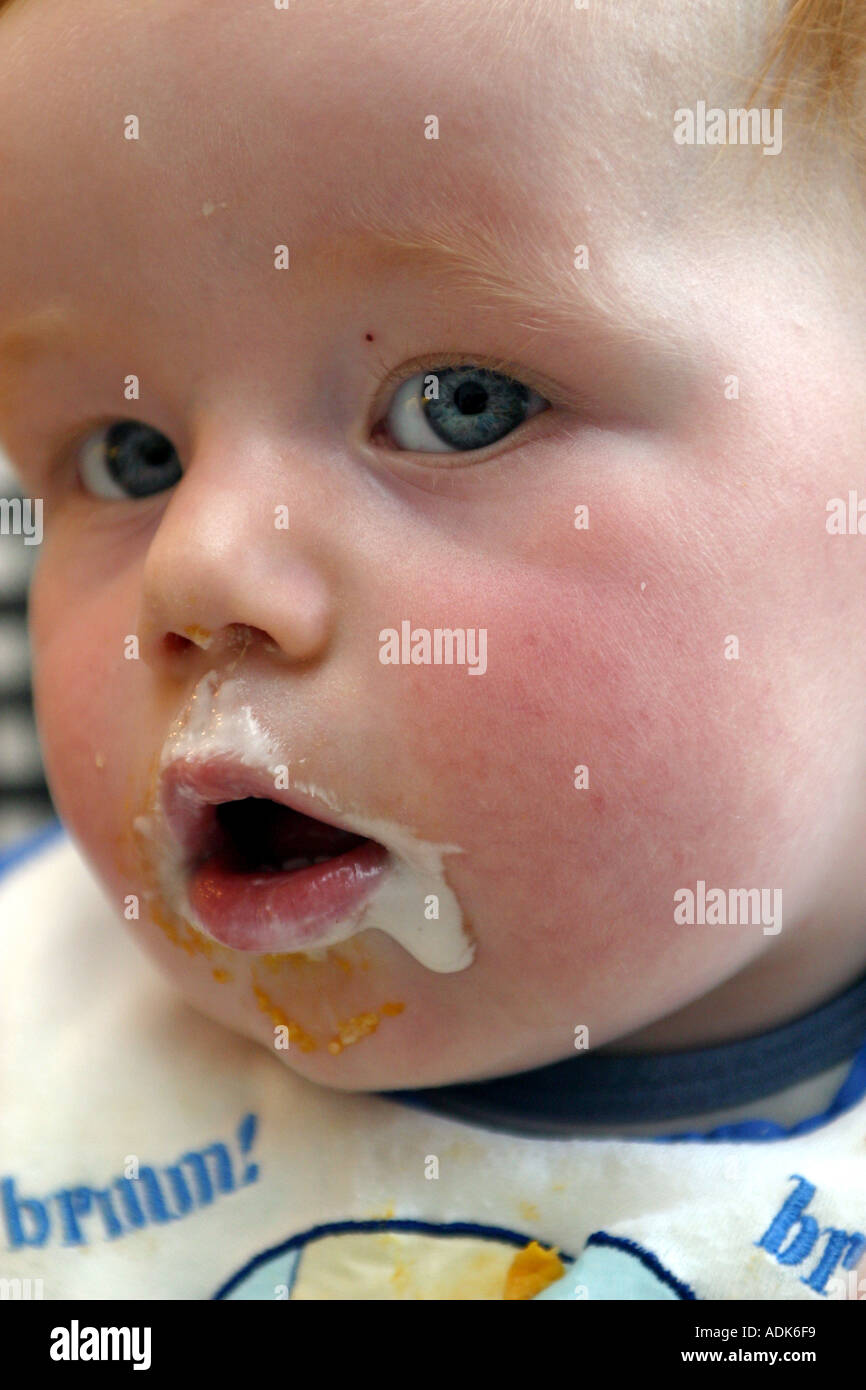 A baby after eating with a messy face and mouth Stock Photo - Alamy