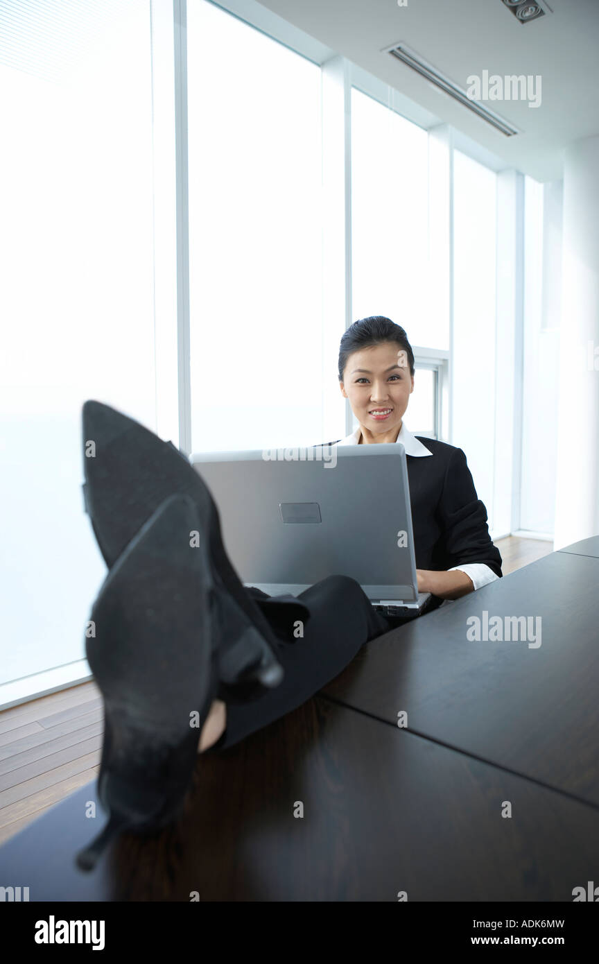 a businesswoman putting her feet on the desk Stock Photo - Alamy