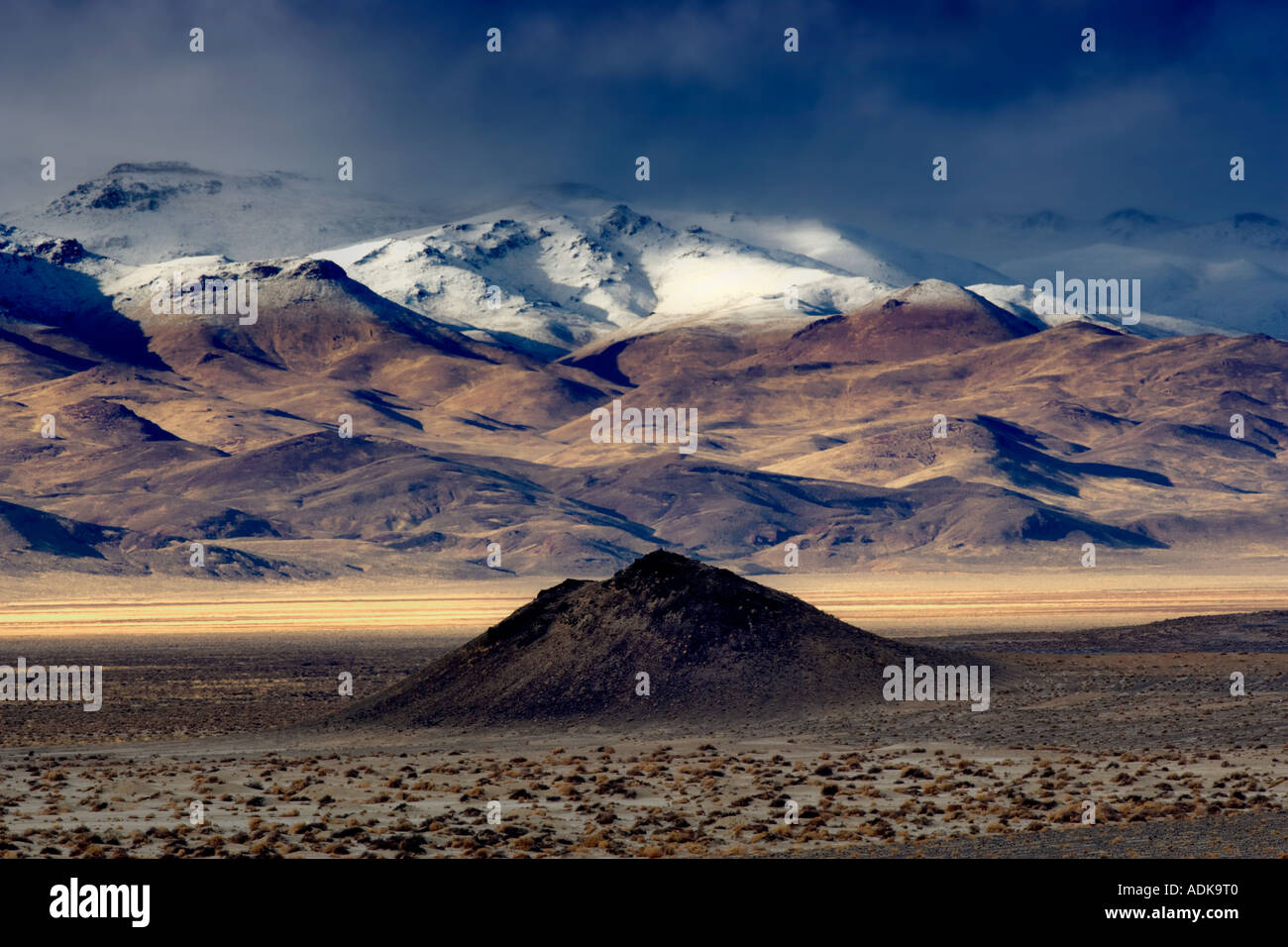 Small cinder cone and snow covered mountains Black Rock Desert National ...