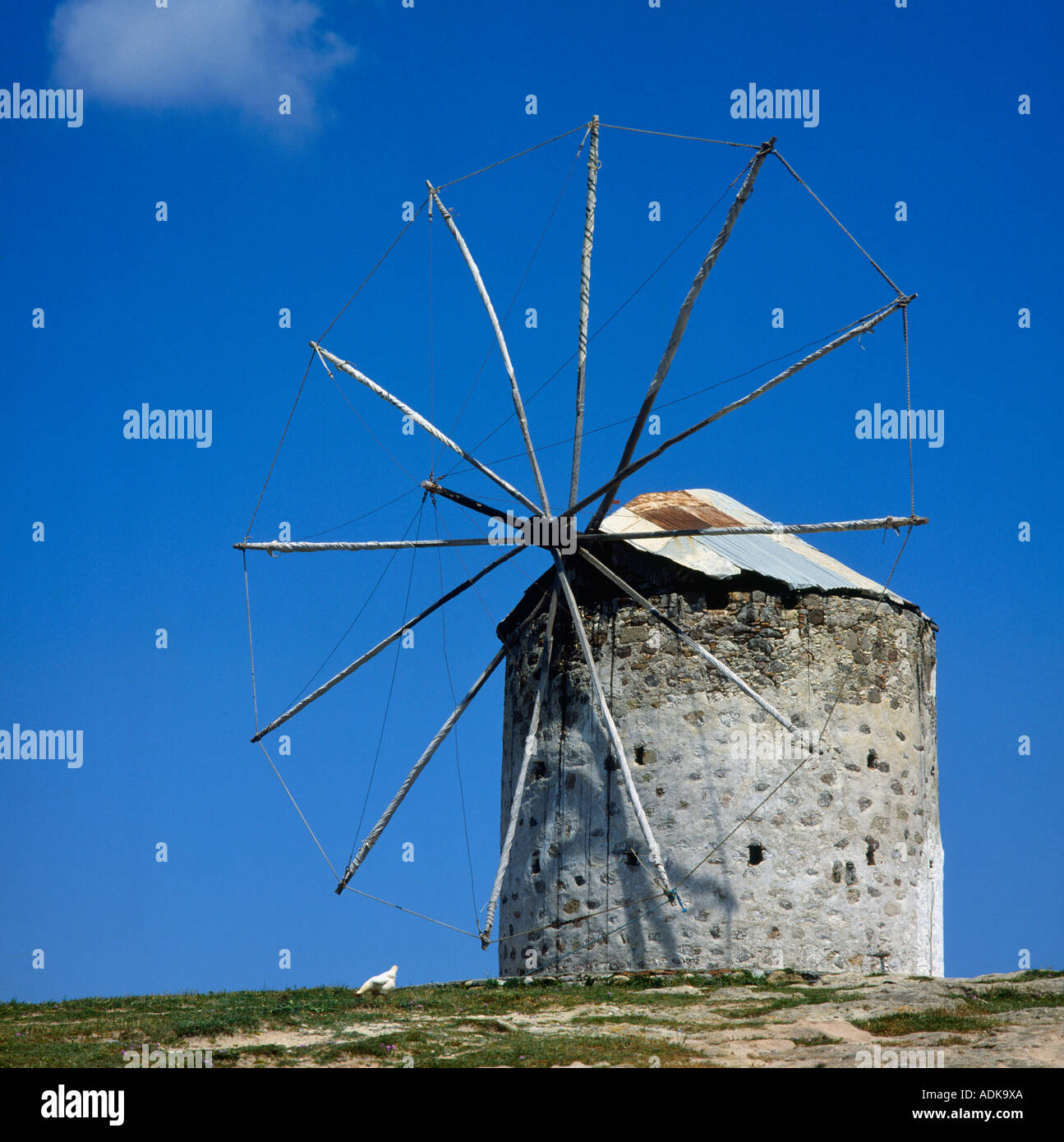 Sun-bleached old stone circular windmill, sail-less against a clear ...