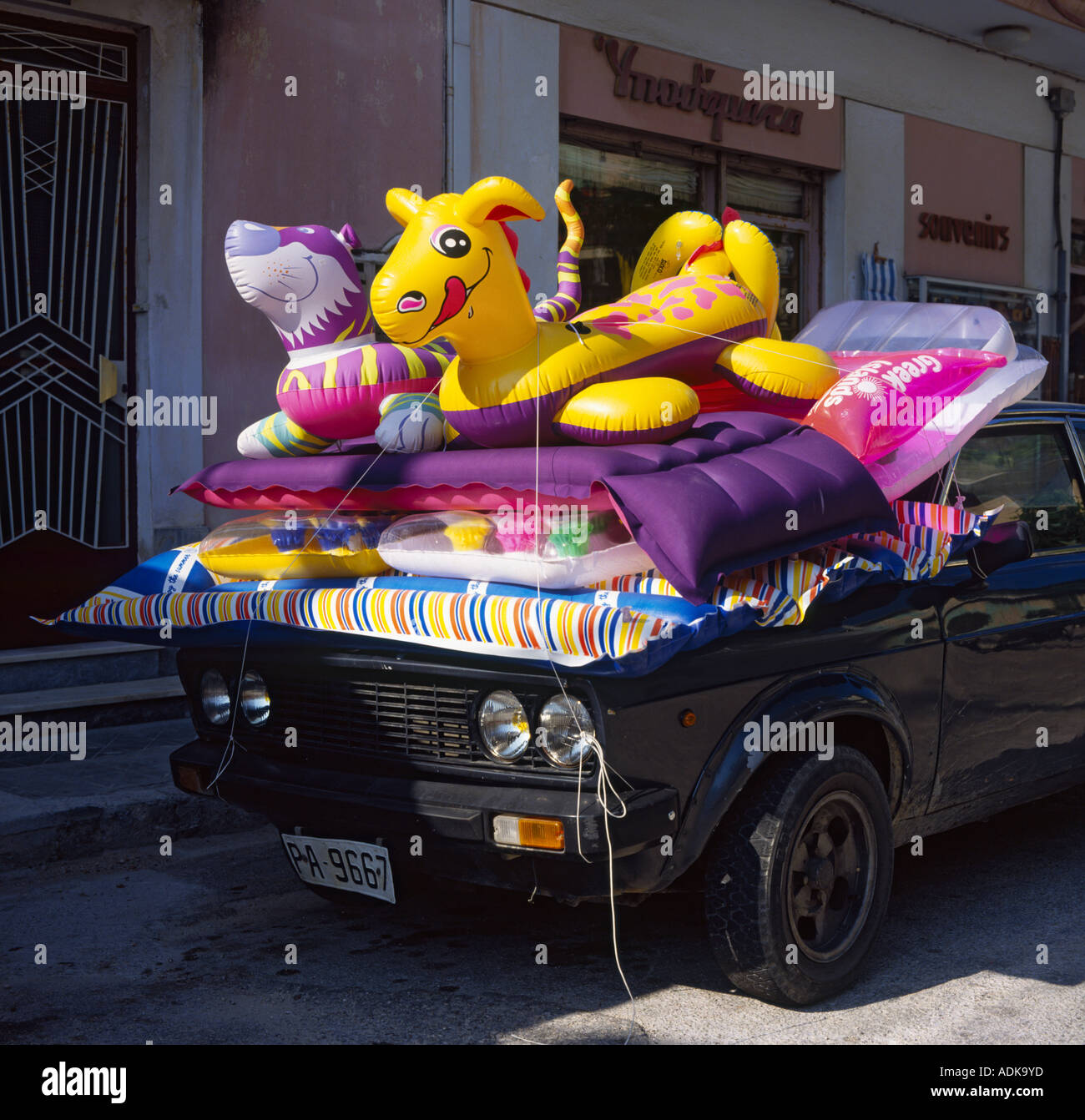 Old black car with display of inflatable lilos sunbeds and toys on ...