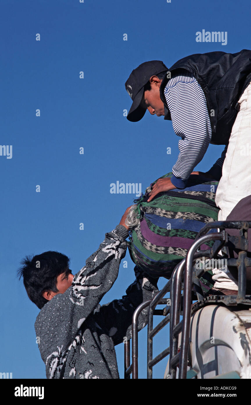 Guatemalan bus company employees loading baggage aboard a bus on the ...