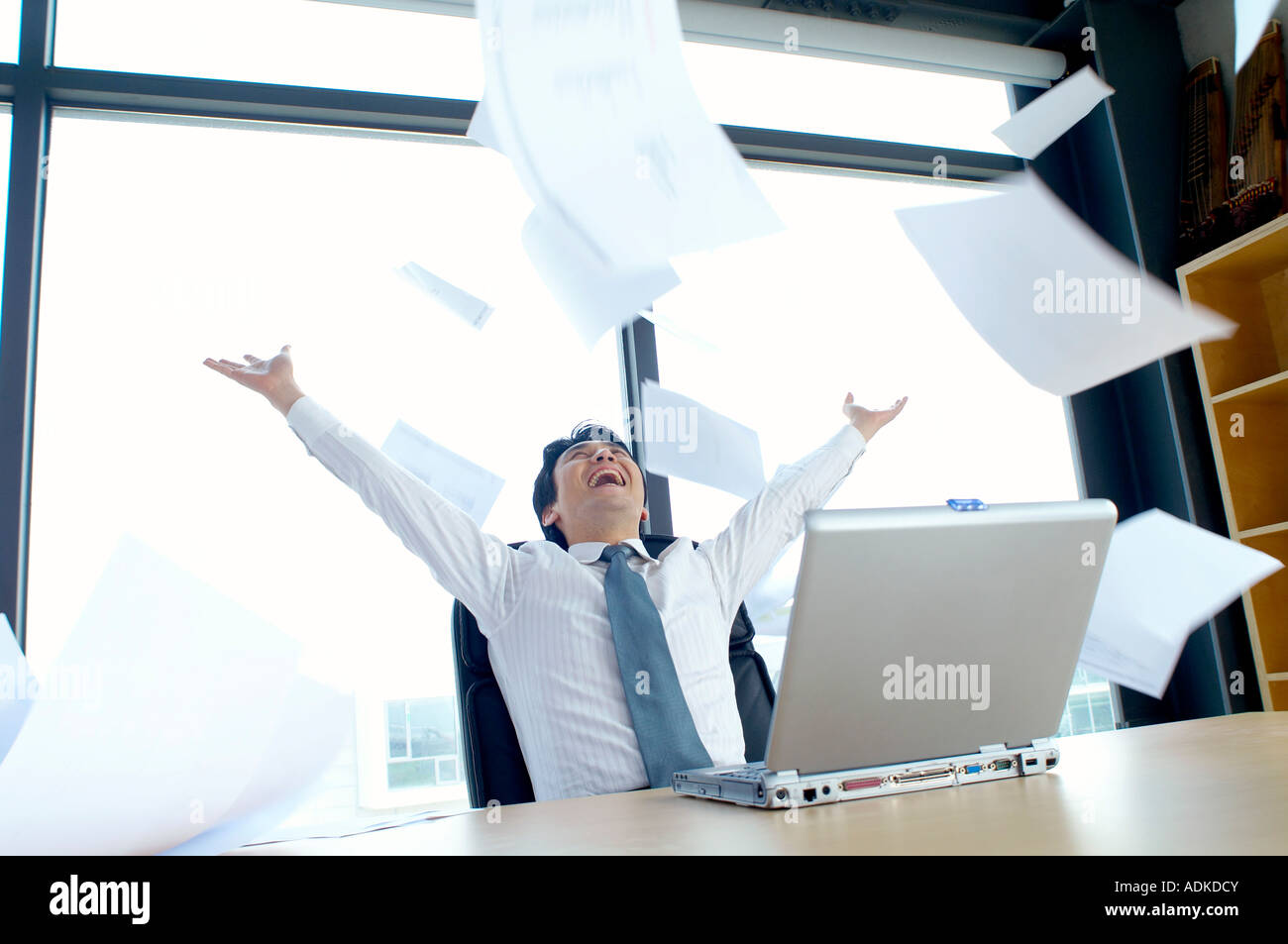 a businessman throwing up a document Stock Photo - Alamy