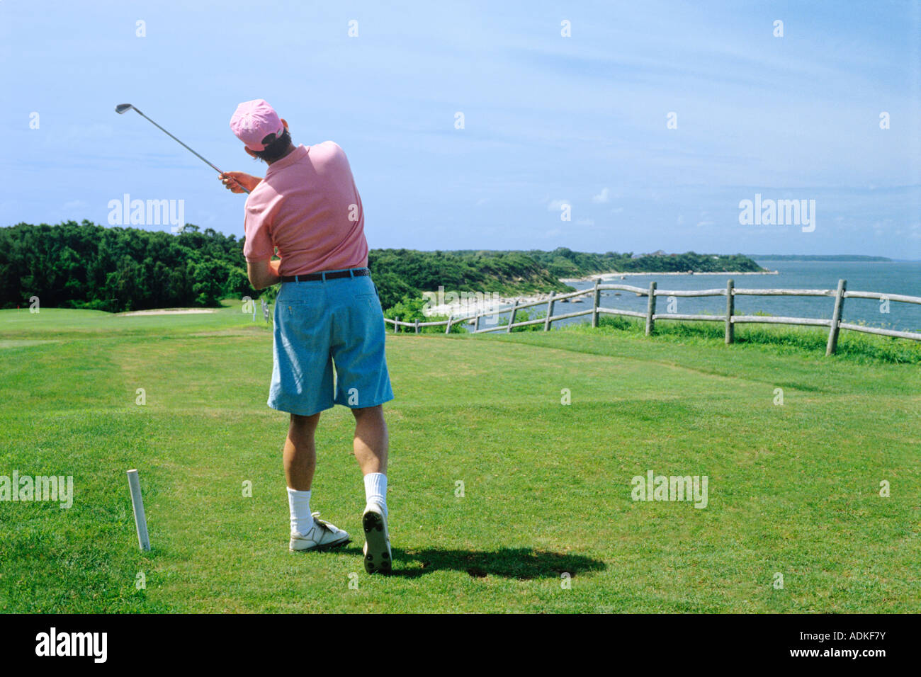 Man in pink and blue on golf course Stock Photo - Alamy