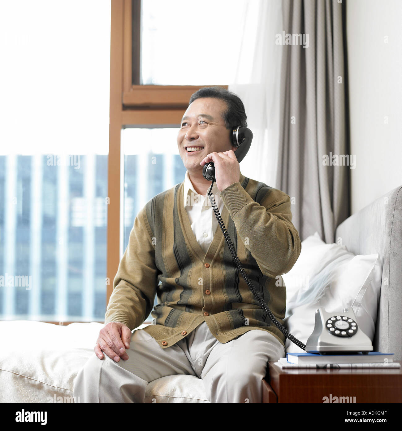 a calling old man on a bed Stock Photo - Alamy