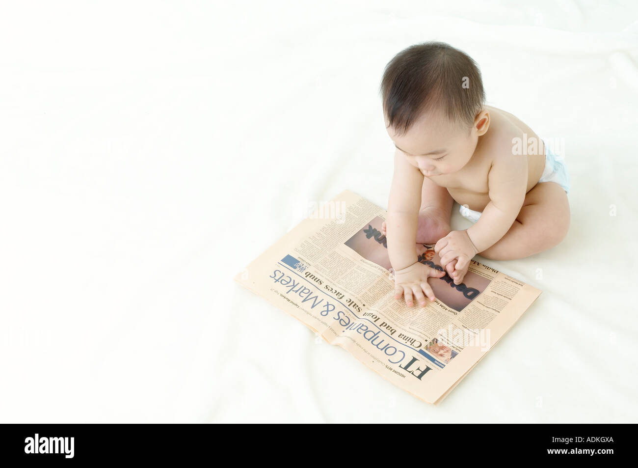 a baby reading a newspaper Stock Photo - Alamy