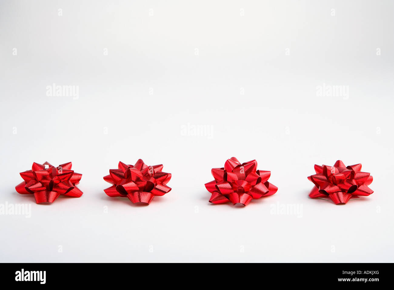 Five bright red Christmas gift bows in row on white background studio ...