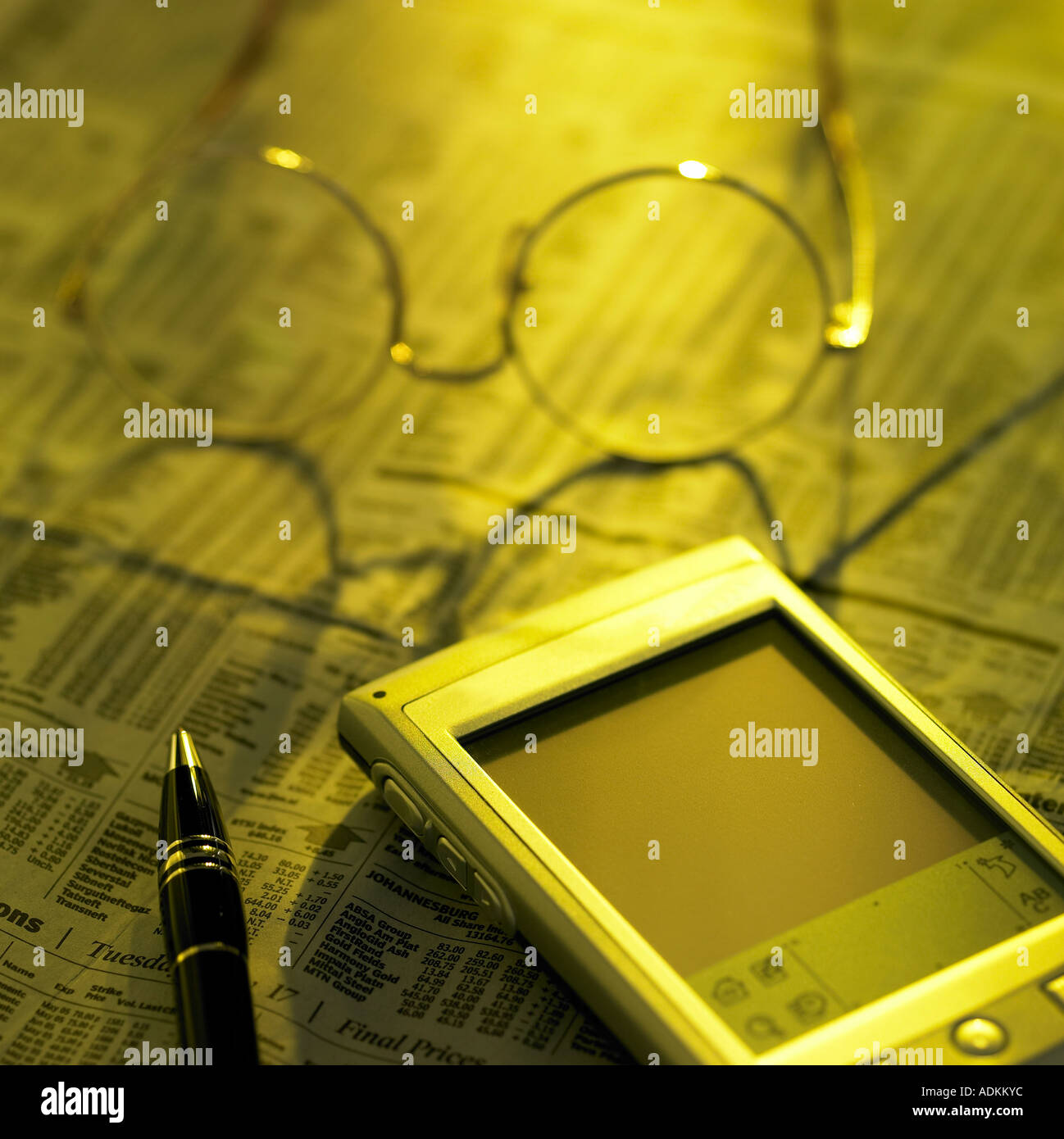 business article a PDA and a pen on a newspaper Stock Photo - Alamy