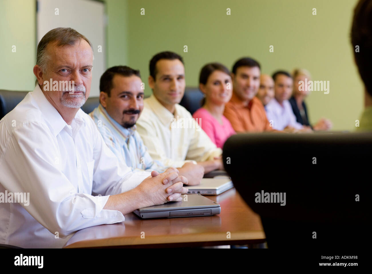 Portrait of a group of business executives sitting around a conference ...