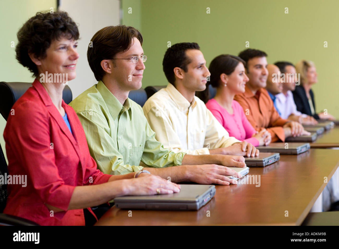 Side profile of a group of business executives sitting around a ...