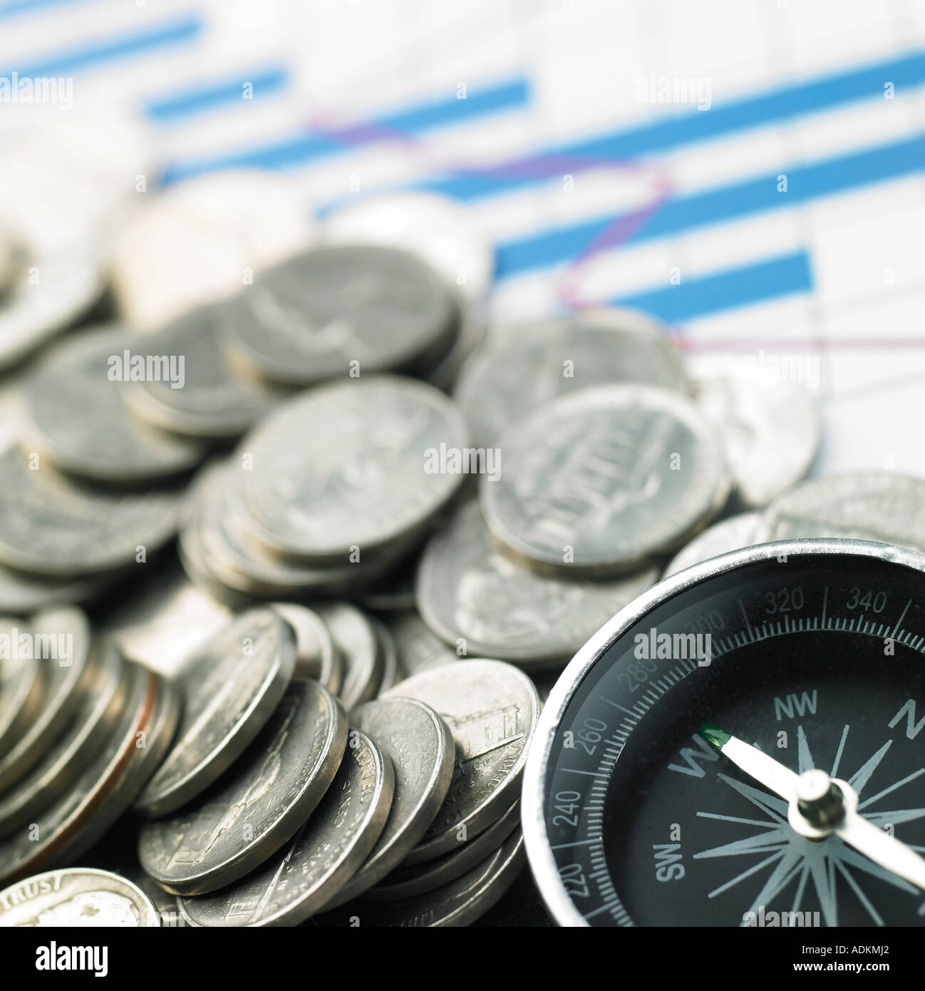 finance coins and a compass Stock Photo - Alamy