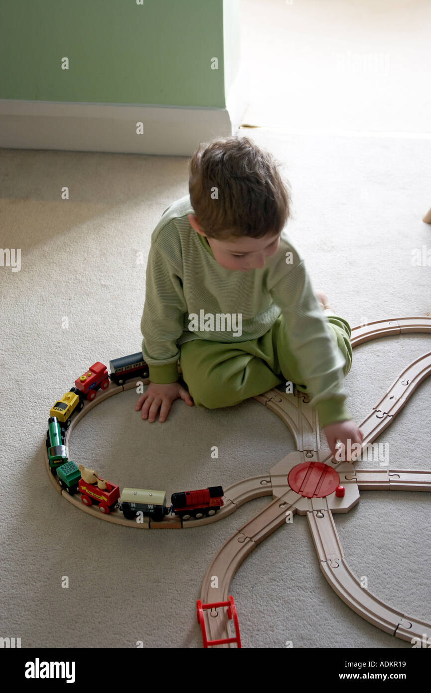 Young boy playing with a train set toy in his bedroom Stock Photo - Alamy