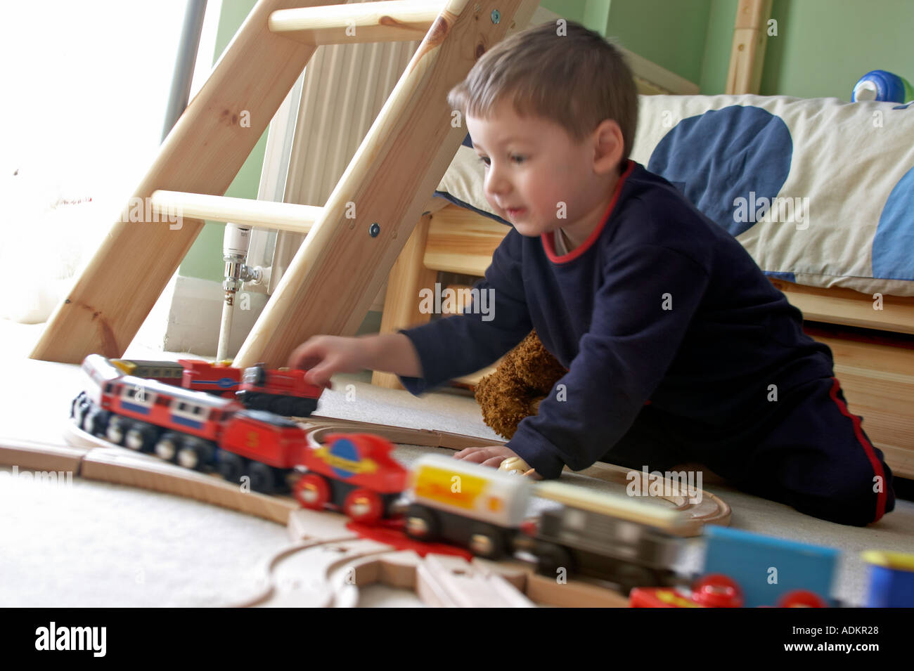 Young boy playing with train set and toys in a bedroom Stock Photo - Alamy
