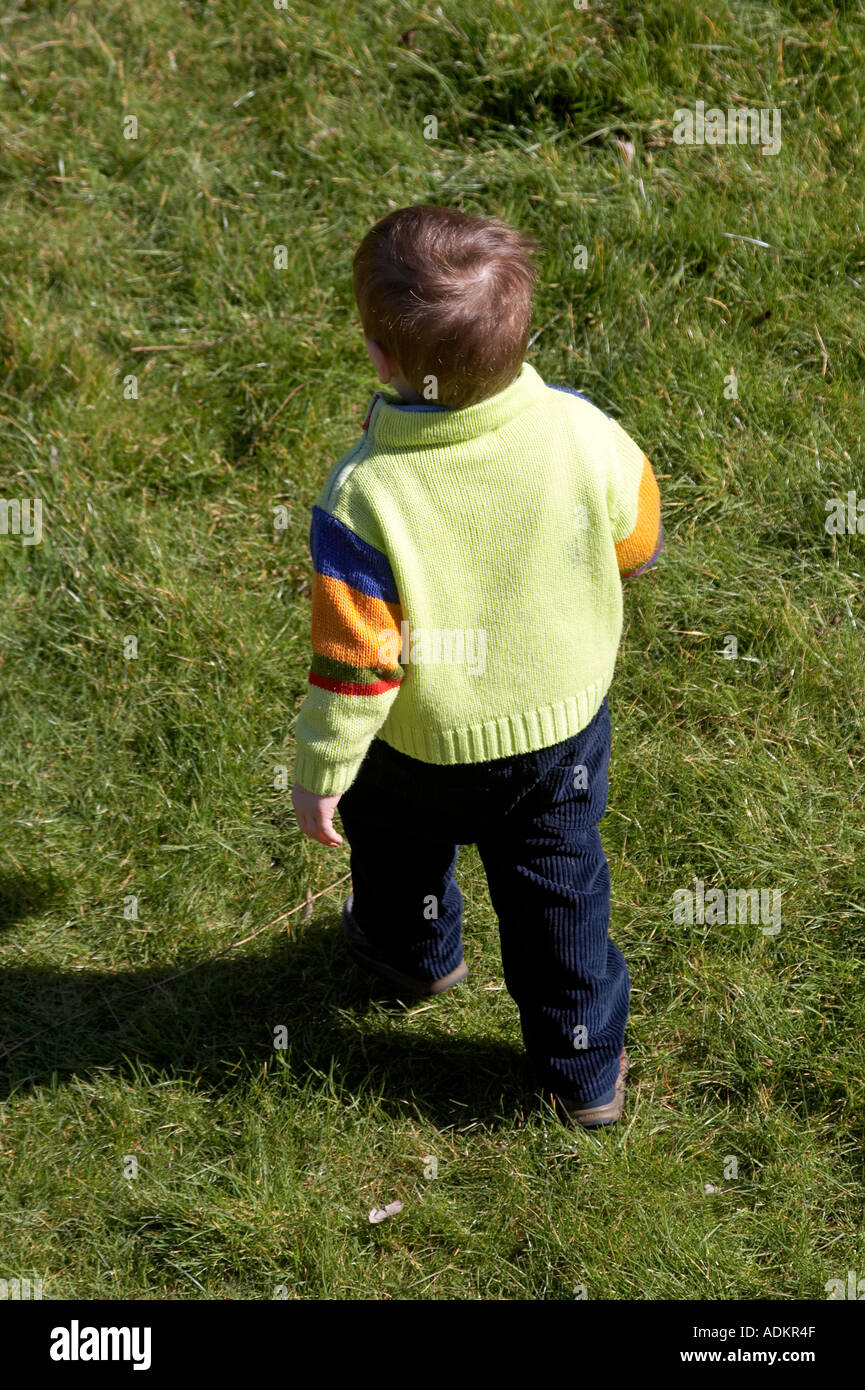 Young boy walking away on a garden lawn outside from above Stock Photo ...