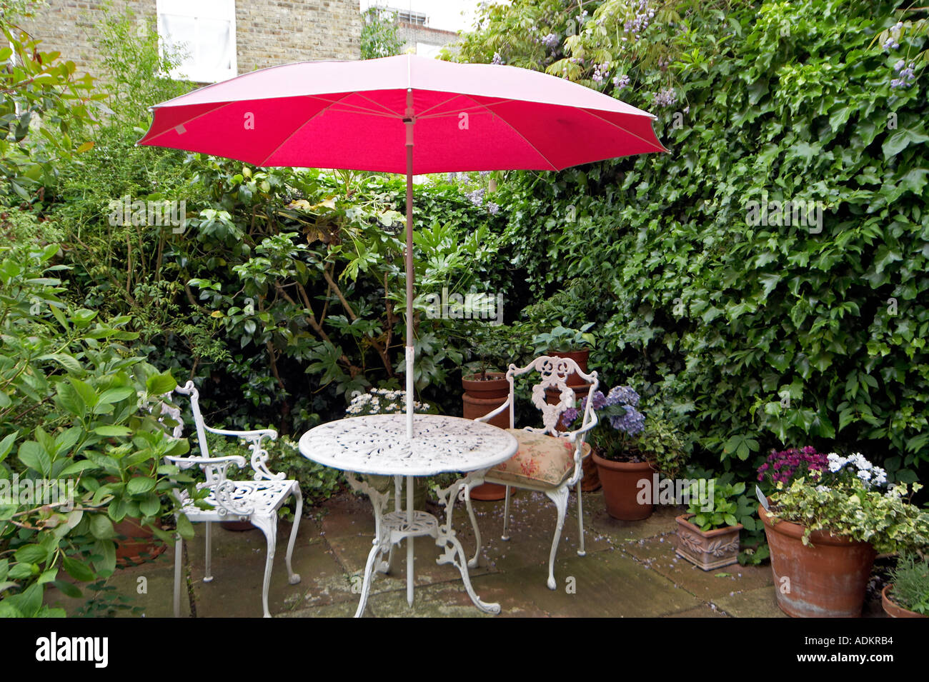 Garden chairs and parasol on patio Stock Photo - Alamy