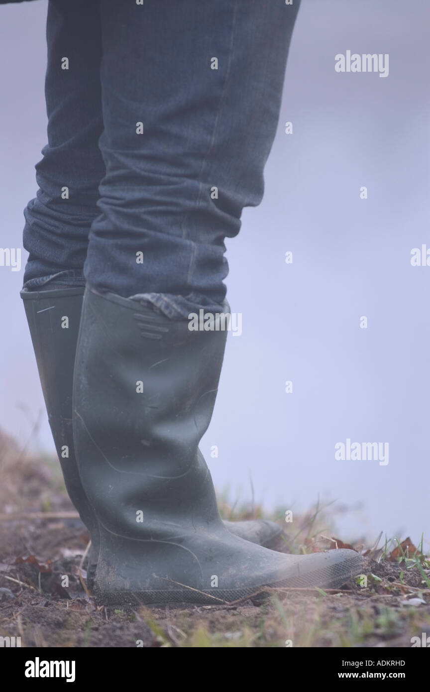 man standing in wellies at river edge Stock Photo - Alamy