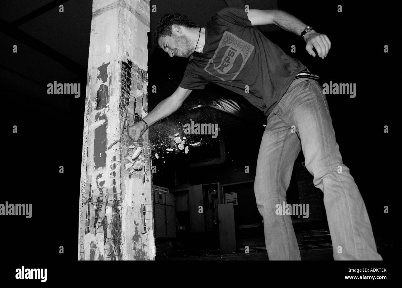 young male man teenager punching punch hitting brick wall with clenched ...