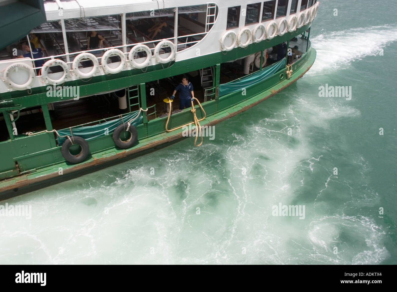 Star Ferry "Twinkling Star's" engines stir up the water as it comes in ...