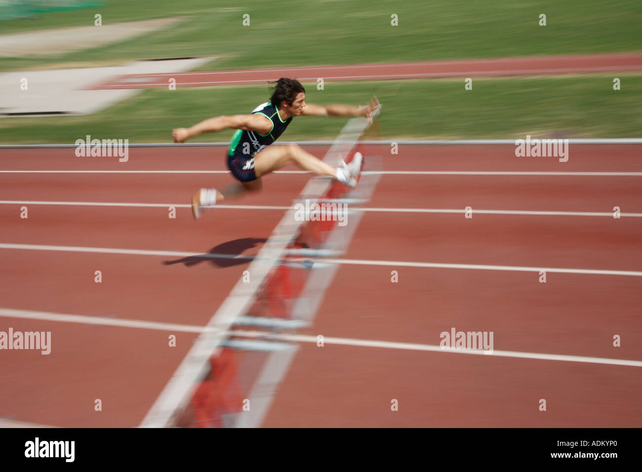 Male Runner Clearing a Hurdle Stock Photo - Alamy