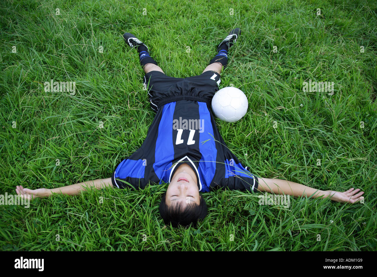 Young Man Sleeping Next To A Soccer Ball In a Field Stock Photo - Alamy
