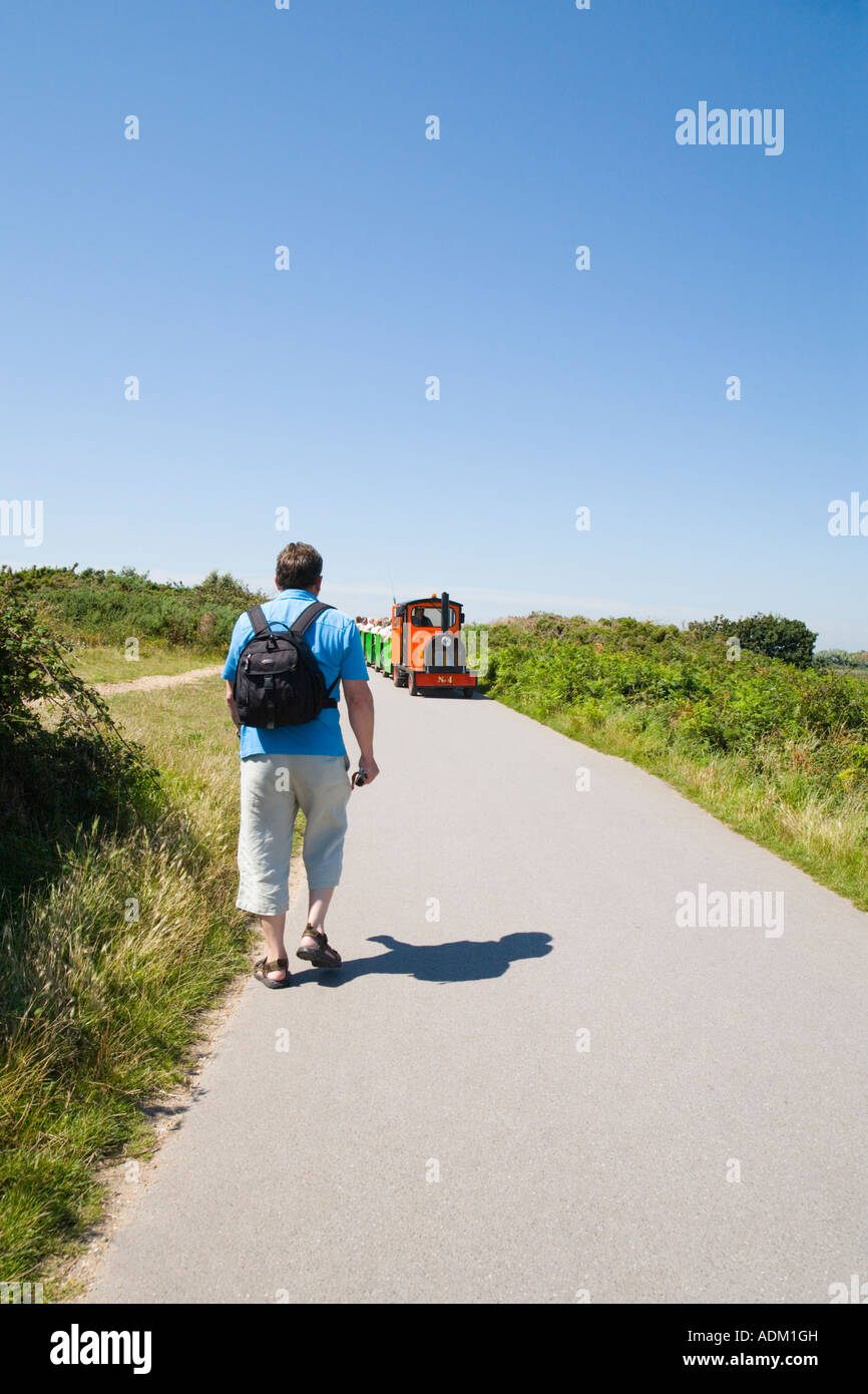 One man walking on Hengistbury Head towards the oncoming land train ...