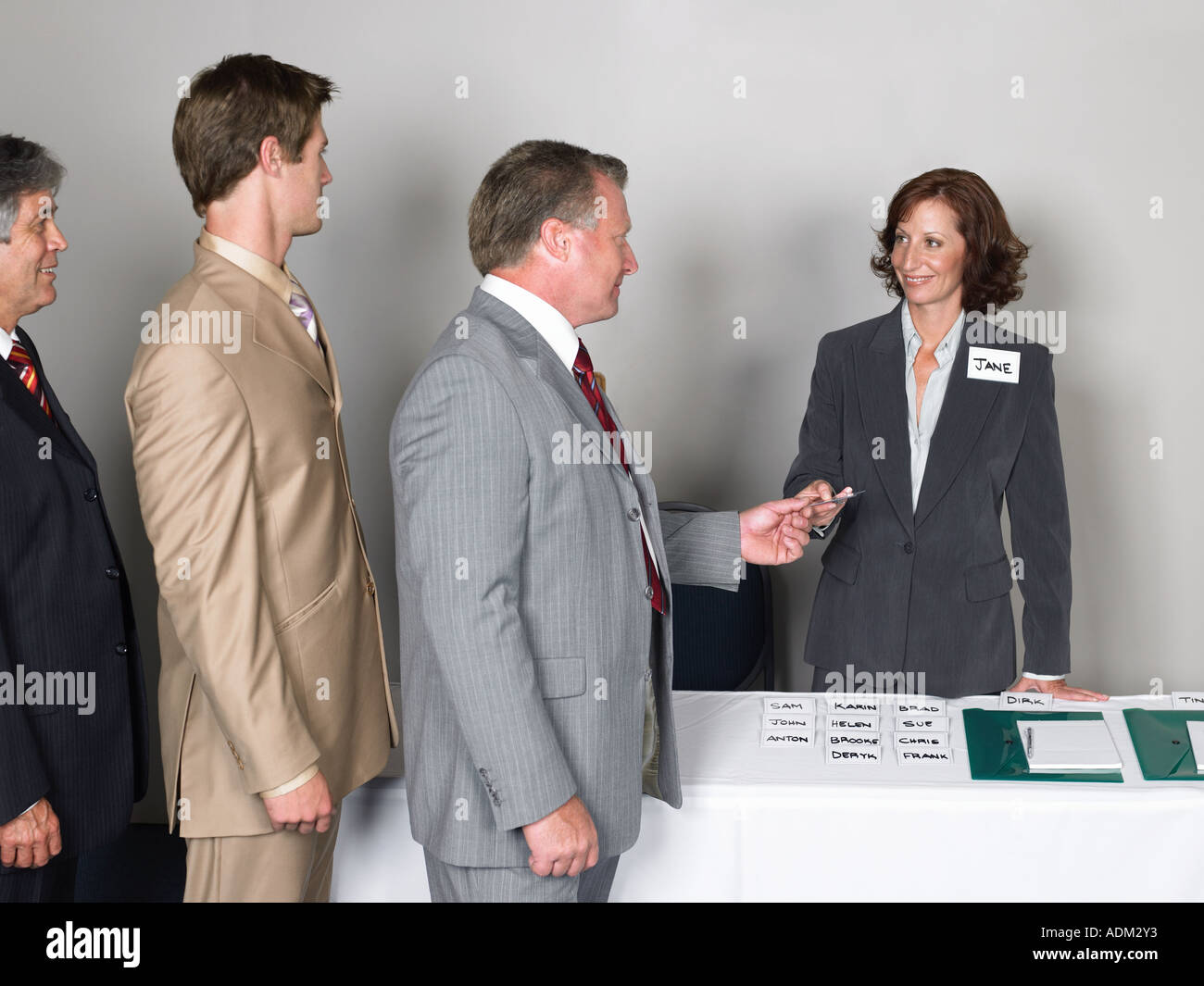 Businesswoman giving out name tags Stock Photo - Alamy