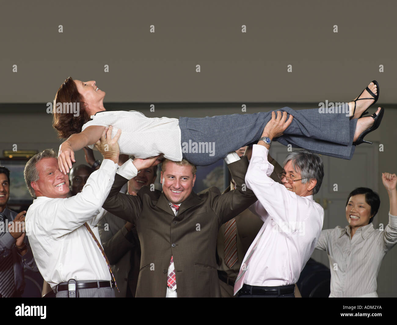 Office workers lifting colleague Stock Photo - Alamy