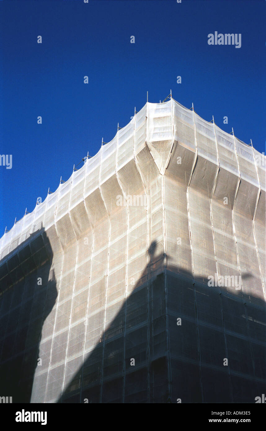 scaffolding and mesh covering big building Stock Photo - Alamy