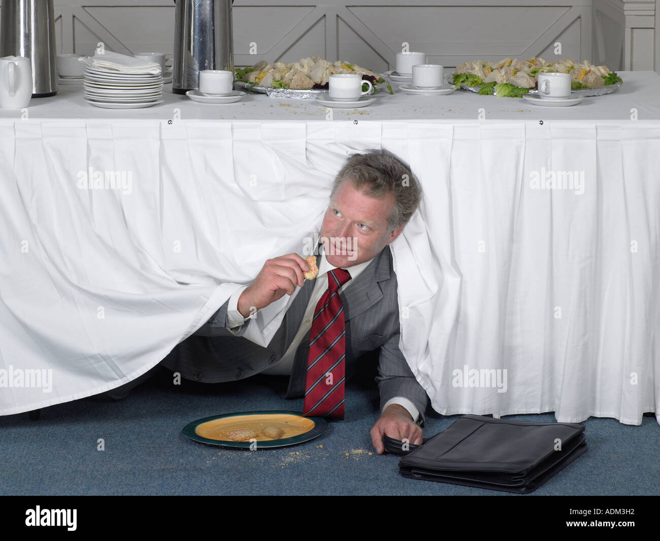 Businessman eating in secret Stock Photo - Alamy