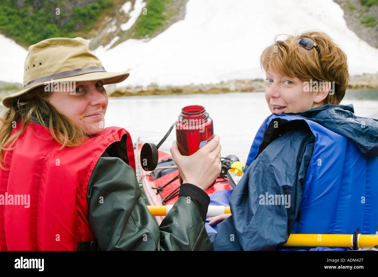 Close up two adult caucasian female kayakers take paddling break in ...
