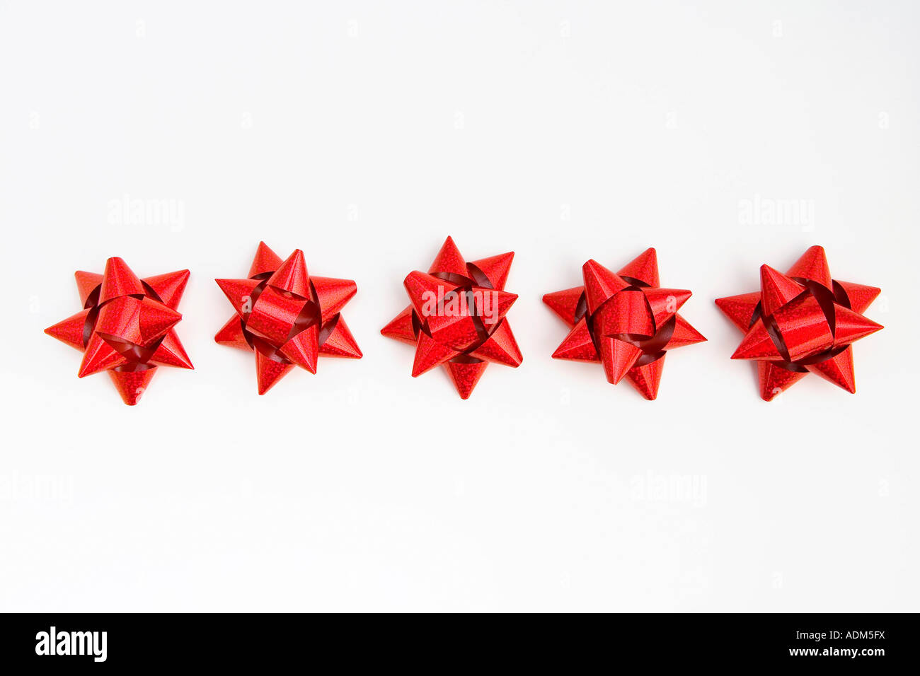 Five bright red Christmas gift bows in row on white background studio ...