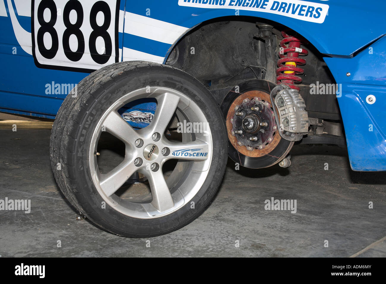 wheel removed from sedan type race car showing brake and suspension ...