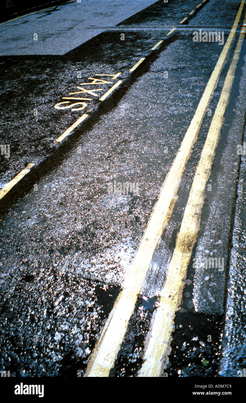 taxi rank and double yellow lines on wet road Stock Photo - Alamy