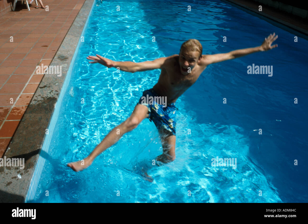 man jumping side on into swimming pool Stock Photo - Alamy