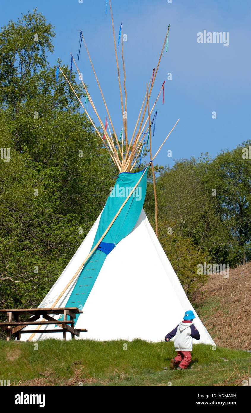 Family group on camping holiday under canvas at specialist teepee ...